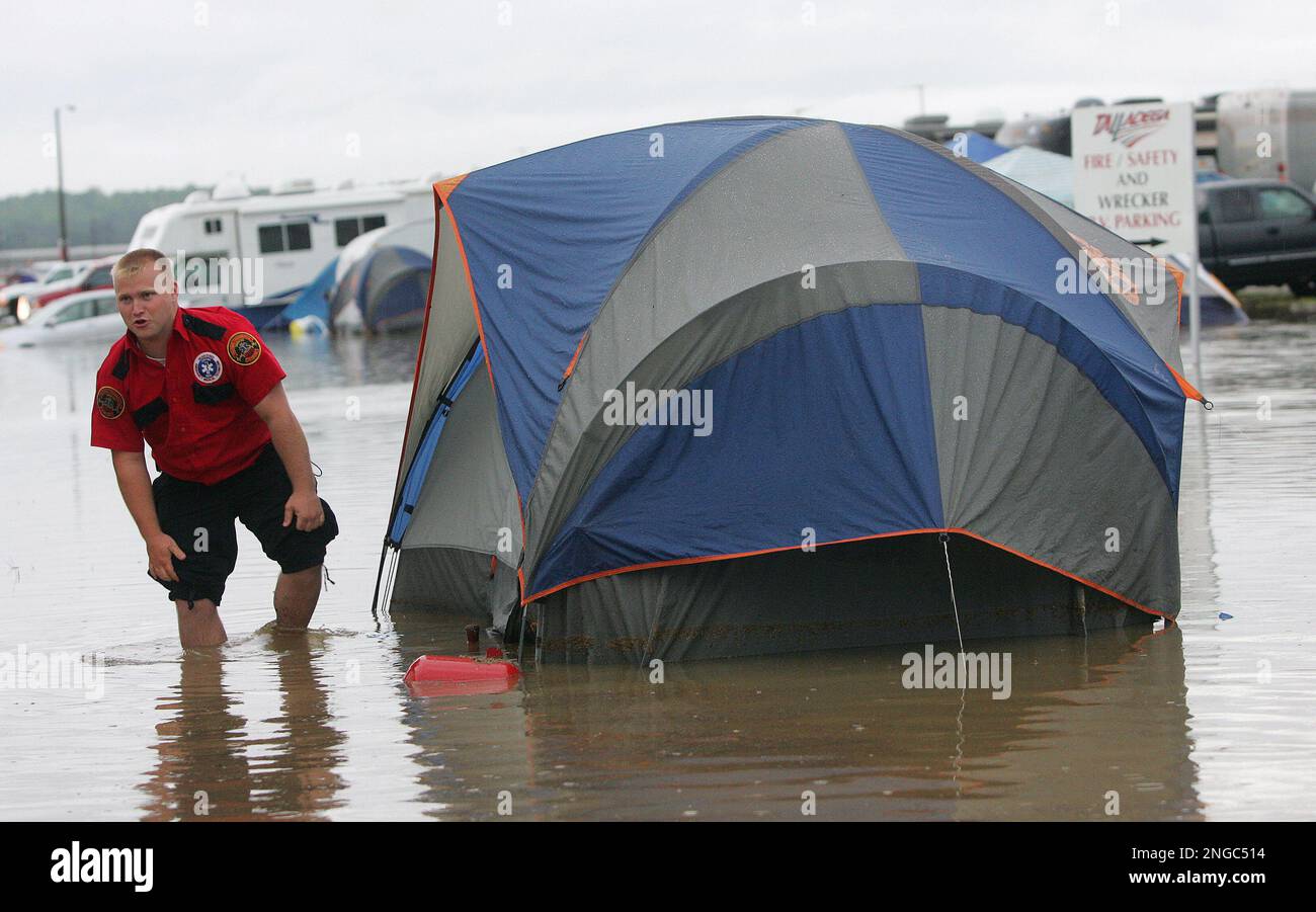 Paramedic Brandon Broadhead walks away from a flooded tent on the ...