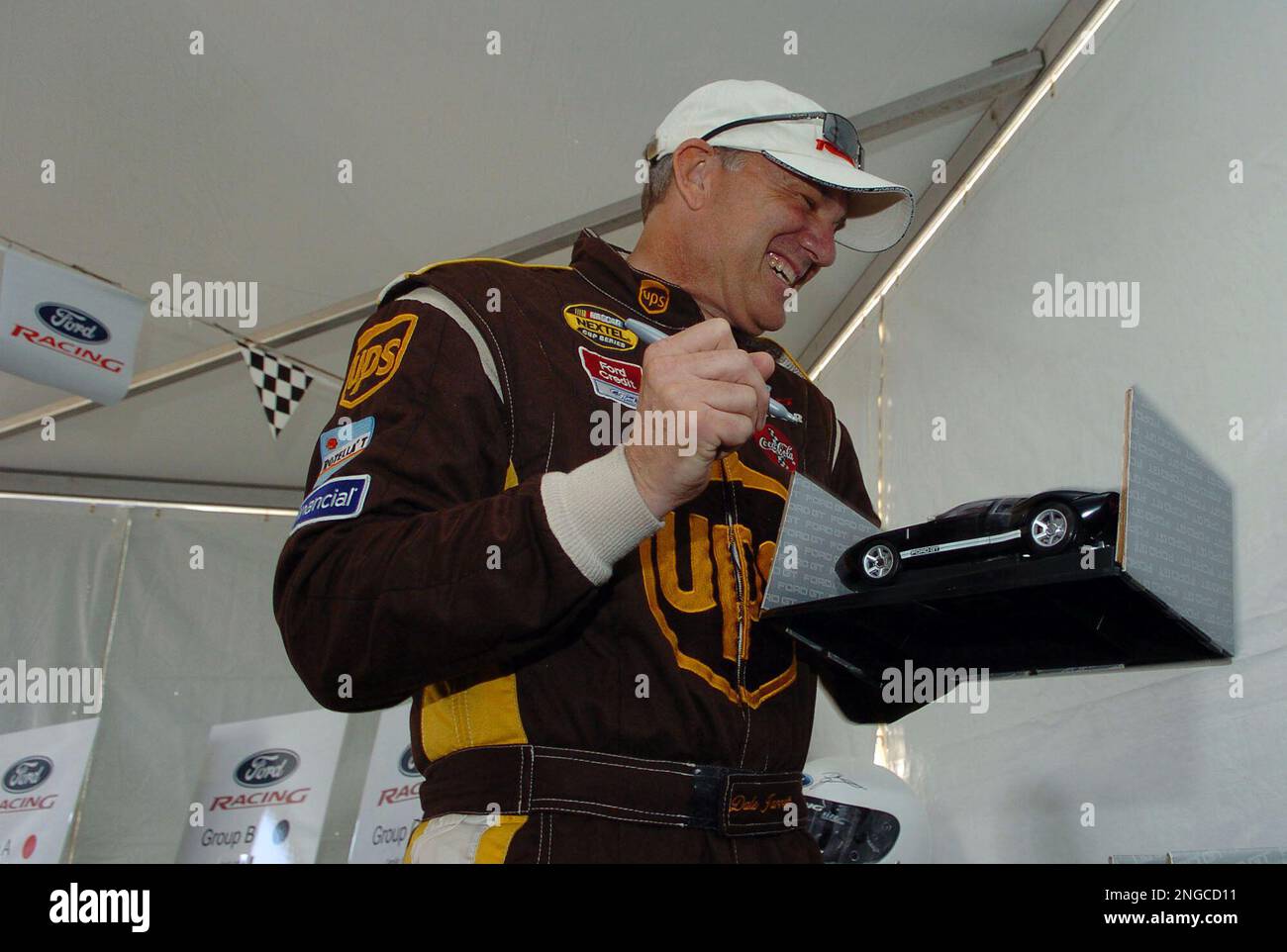 NASCAR driver Dale Jarrett signs one of many toy Ford Mustang GT cars ...