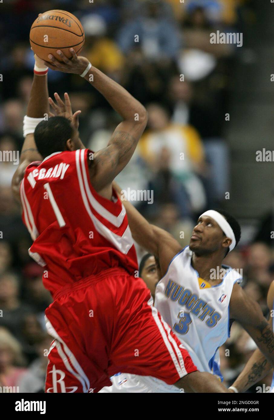 Houston Rockets guard Tracy McGrady, left, shoots over Denver Nuggets ...