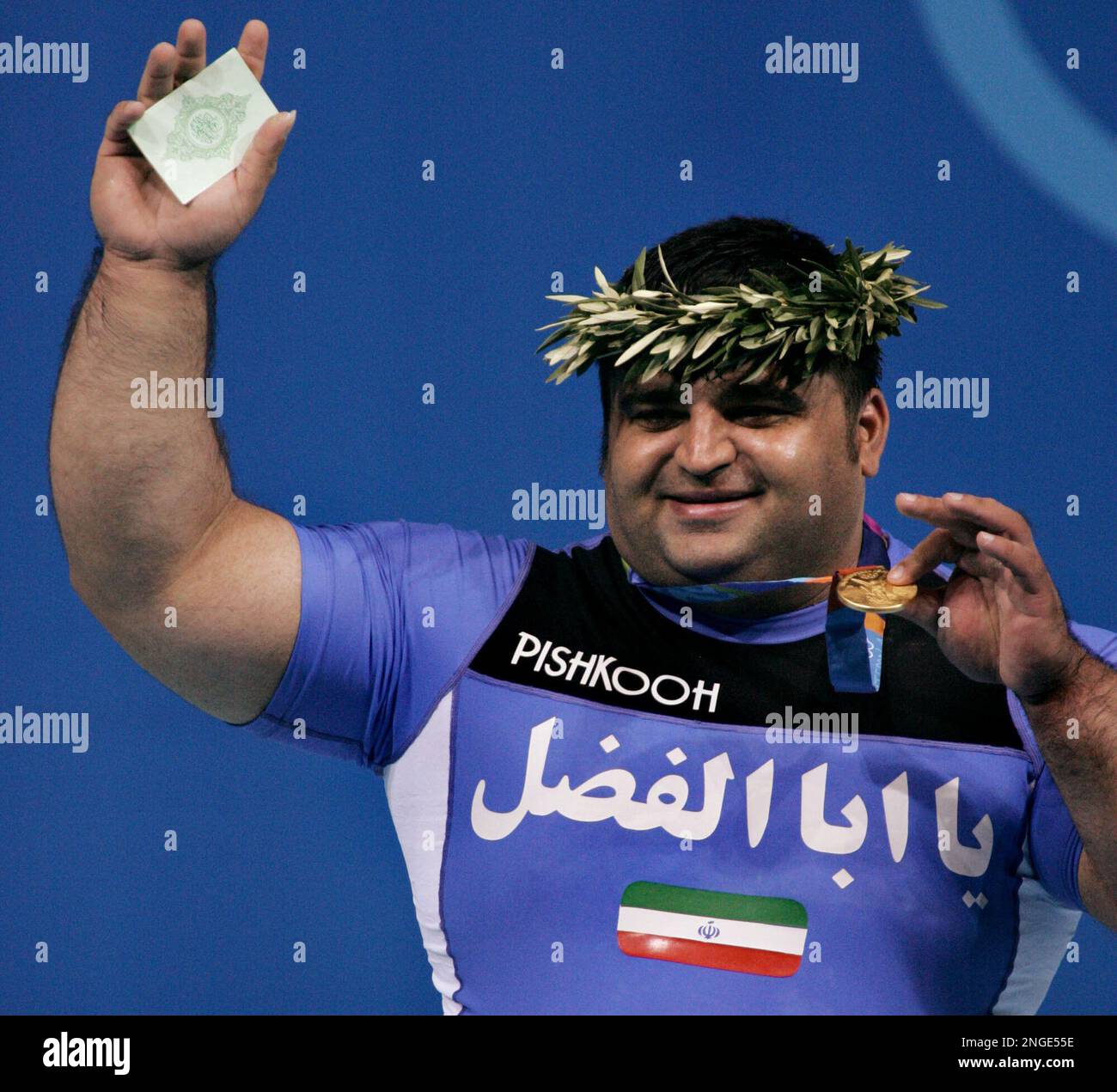 Gold medalist Hossein Reza Zadeh of Iran holds his medal and the Koran ...