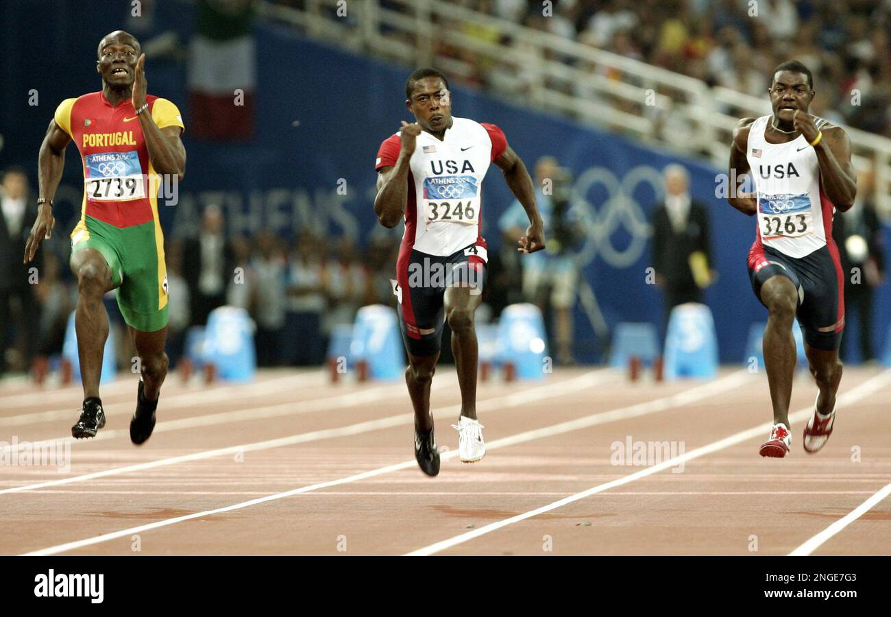 Jason Gatlin, of the United States, right, crosses the finish line to ...