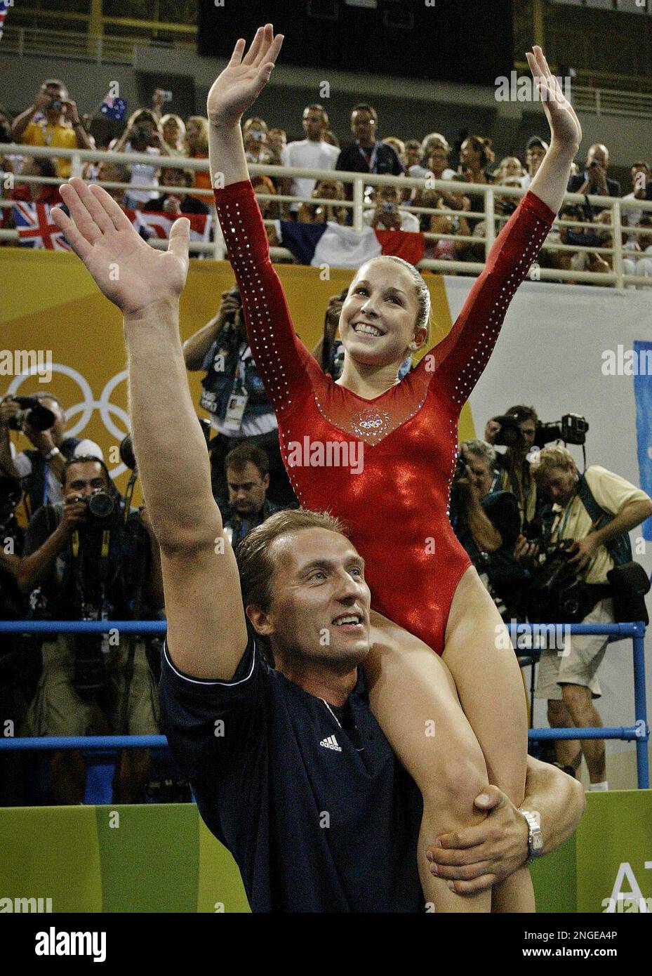 United States' Carly Patterson is lifted up by her coach Evgeny ...