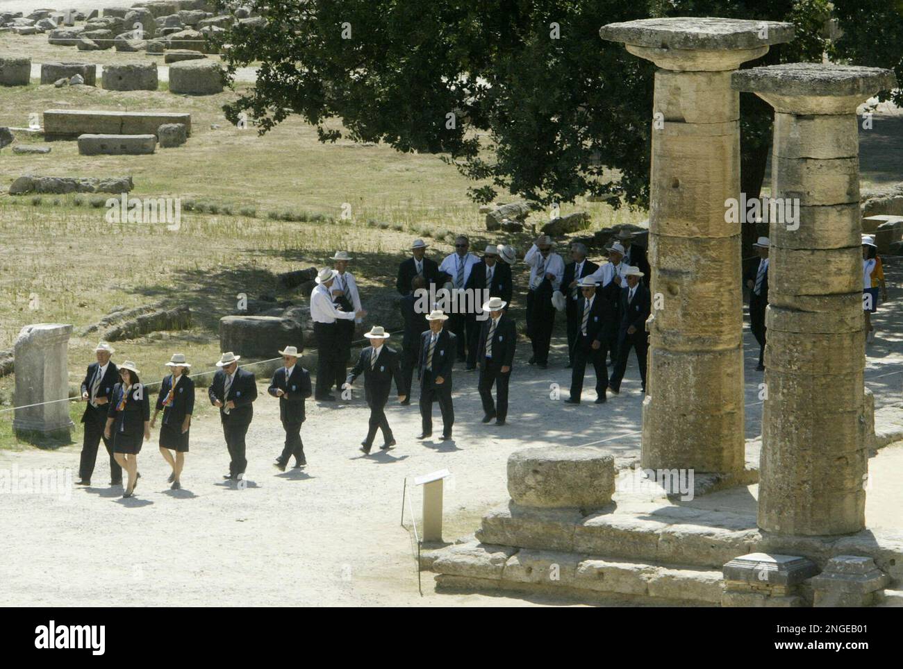 Olympic shot put judges walk past the ruins of the site of the ancient ...