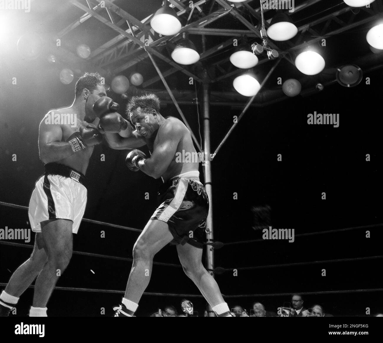 Defending world heavyweight champion Rocky Marciano, in white trunks ...