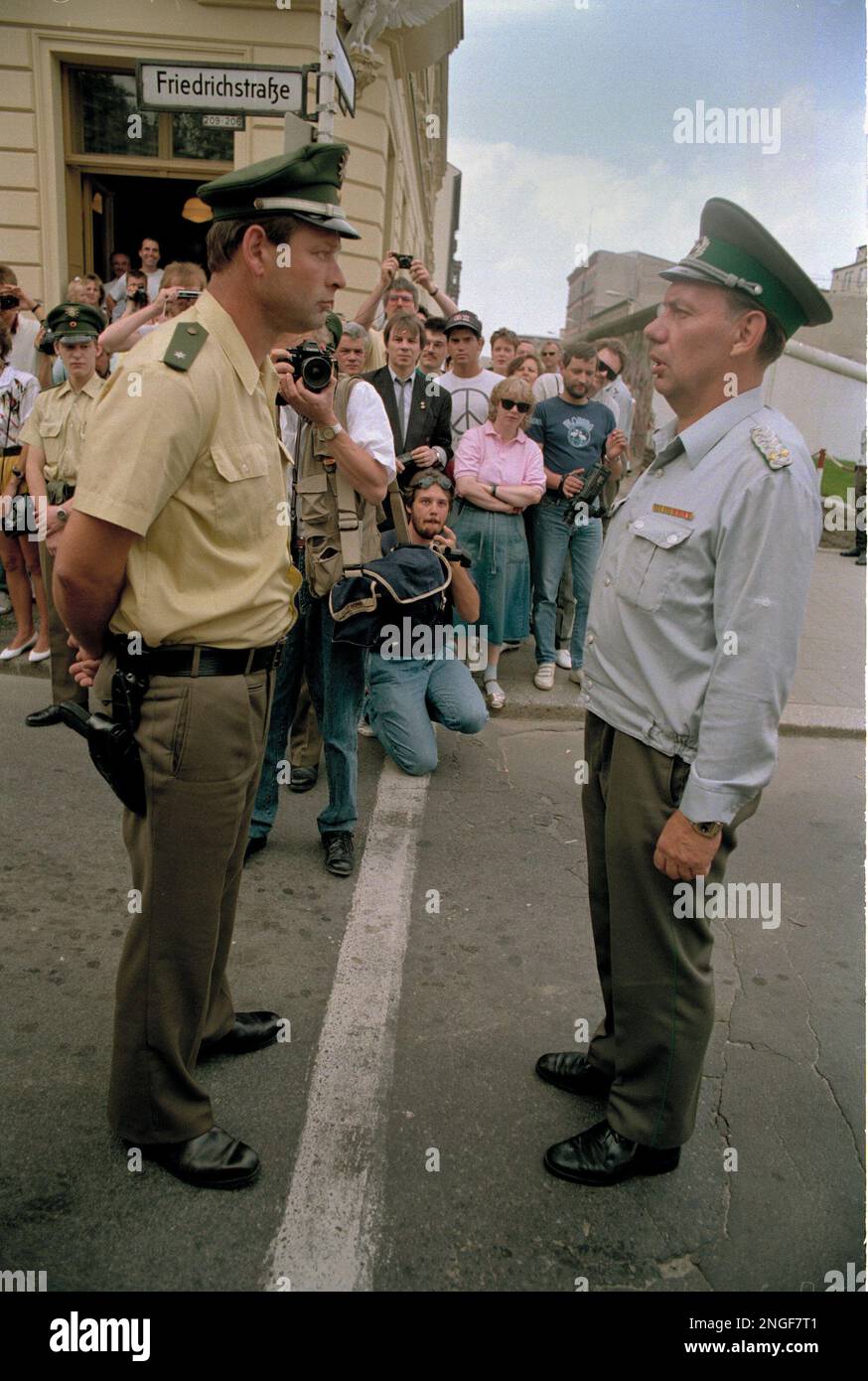 A West German policeman, left, and an East German border guard argue ...