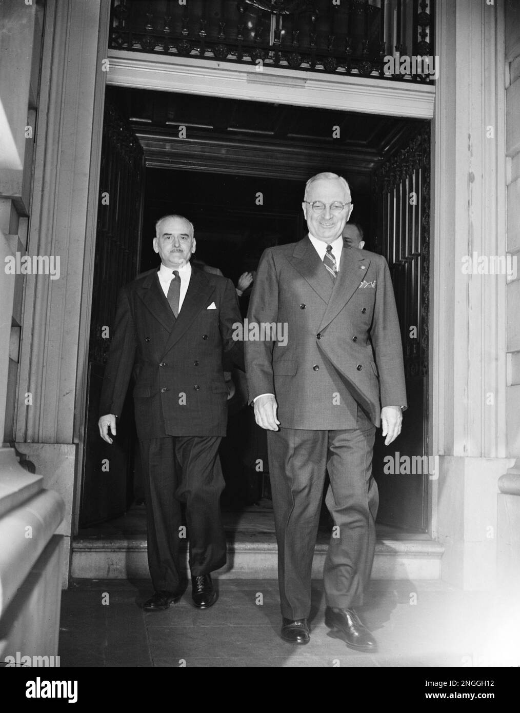 U.S. President Harry S. Truman smiles as he steps along the corridor of ...