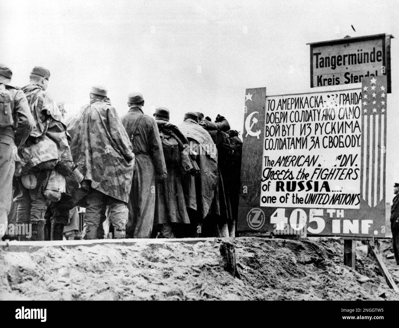 Captured German soldiers pass a Russian-English roadside sign erected ...