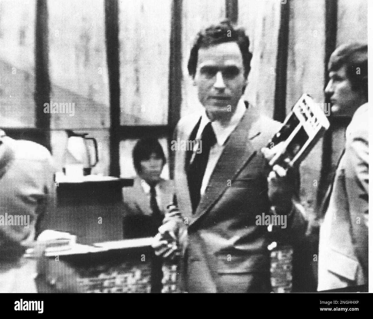 Theodore Bundy turns from the bench to face the media, watching from a television monitor in a ...