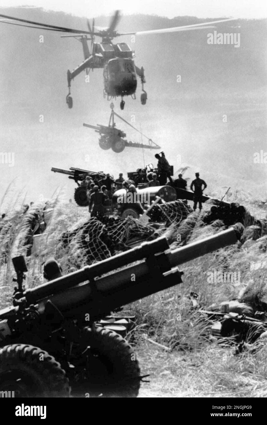A helicopter lifts a 155mm howitzer cannon to the top of a hill during ...