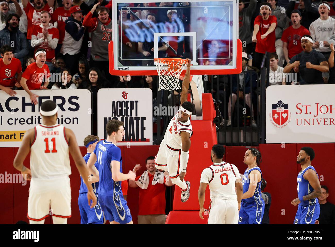 St. John's guard AJ Storr (2) hangs on the basket after dunking the ...