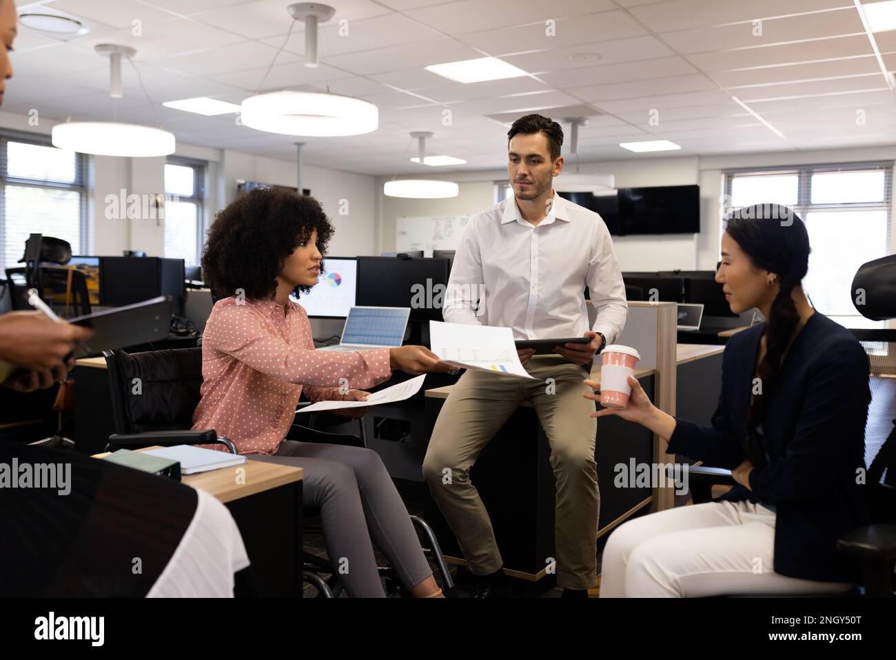 Gruppe unterschiedlicher Personen im Büro, die mit Dokumenten arbeiten ...