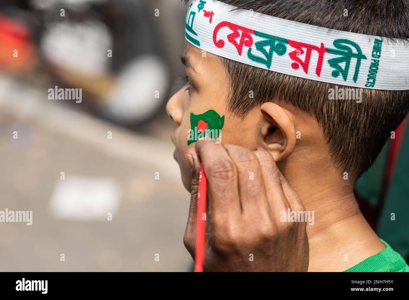 Dhaka, Bangladesch. 21. Februar 2023. Ein Kind mit Farbe im Gesicht am ...