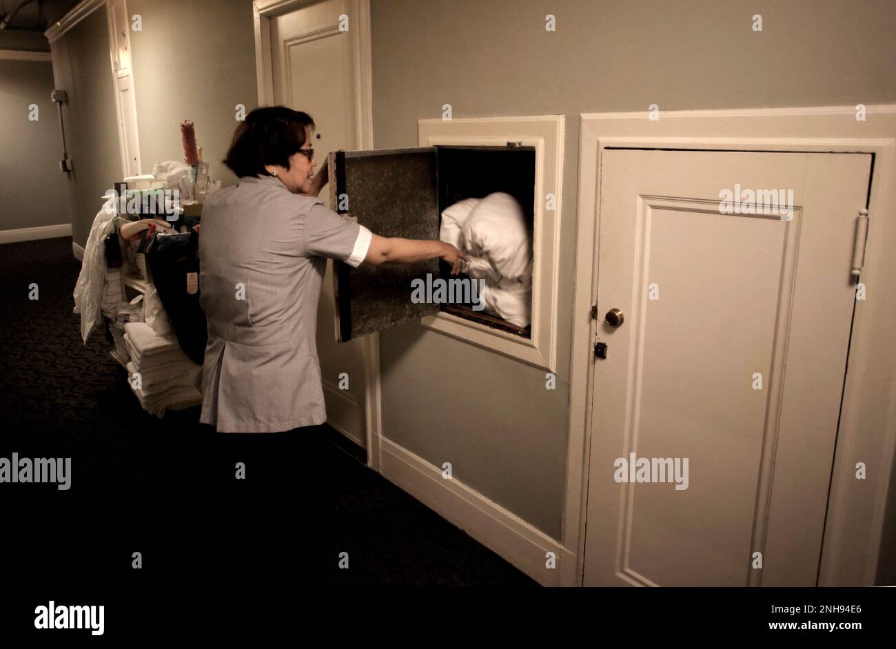 Room attendant, Caridad Rodriguez places linens in then laundry chute ...