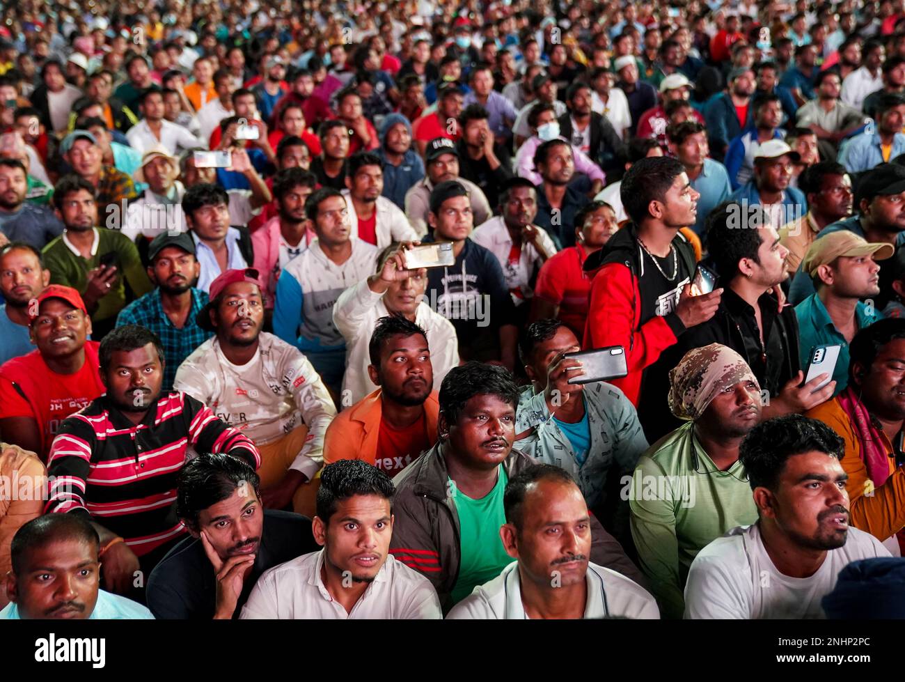 Migrant workers watch soccer on a big projection screen during the World Cup at the Asian Town ...