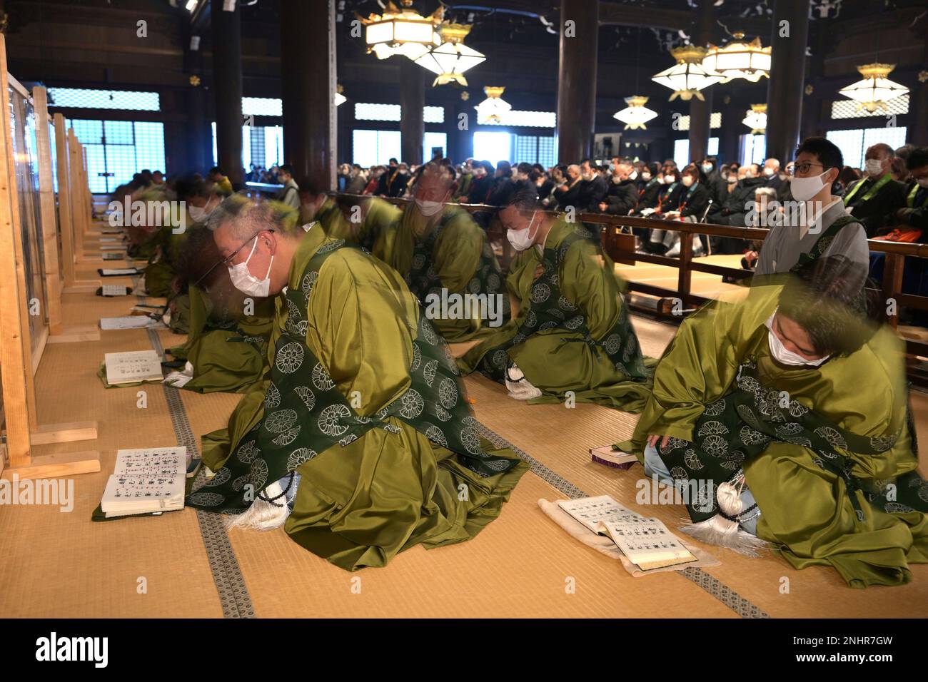 Monks moving their bodies in all directions chant a Buddhist sutra ...
