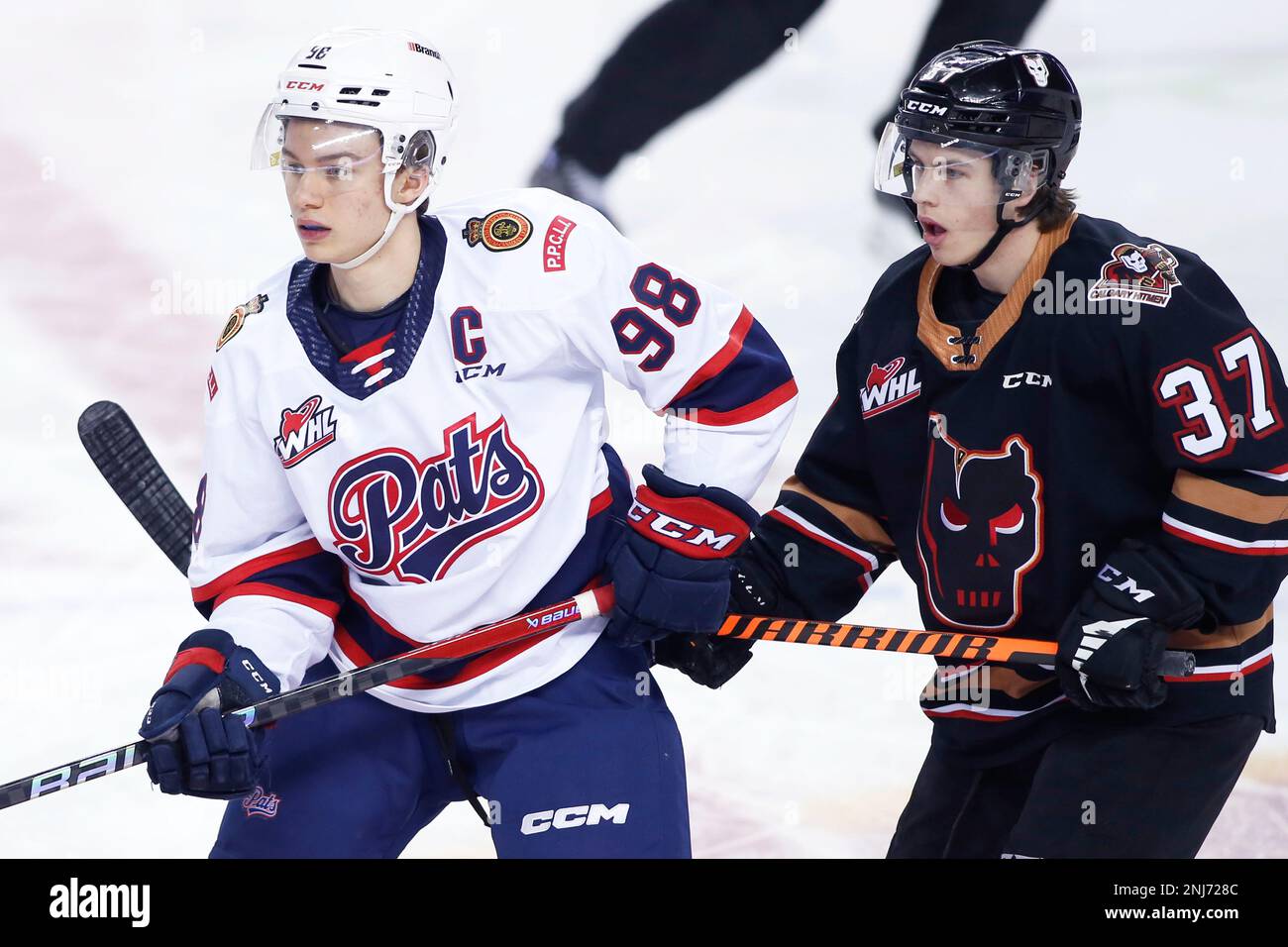 Regina Pats player Connor Bedard, lt, plays against Calgary Hitmen player Oliver Tulk during WHL ...