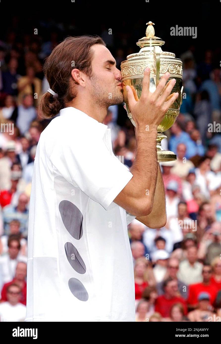 FILE: Roger Federer of Switzerland raises the first victory trophy ...