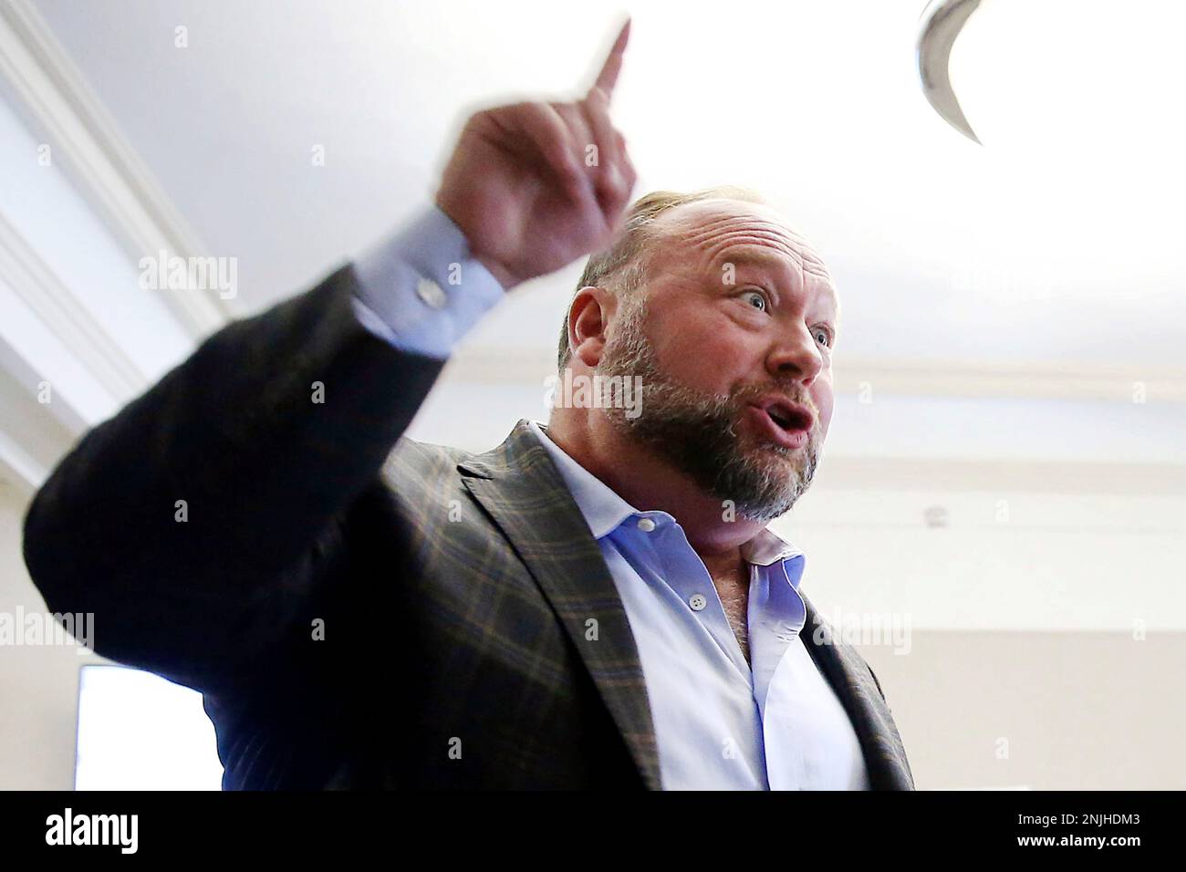 FILE - Alex Jones talks to media during a midday break in his trial at ...