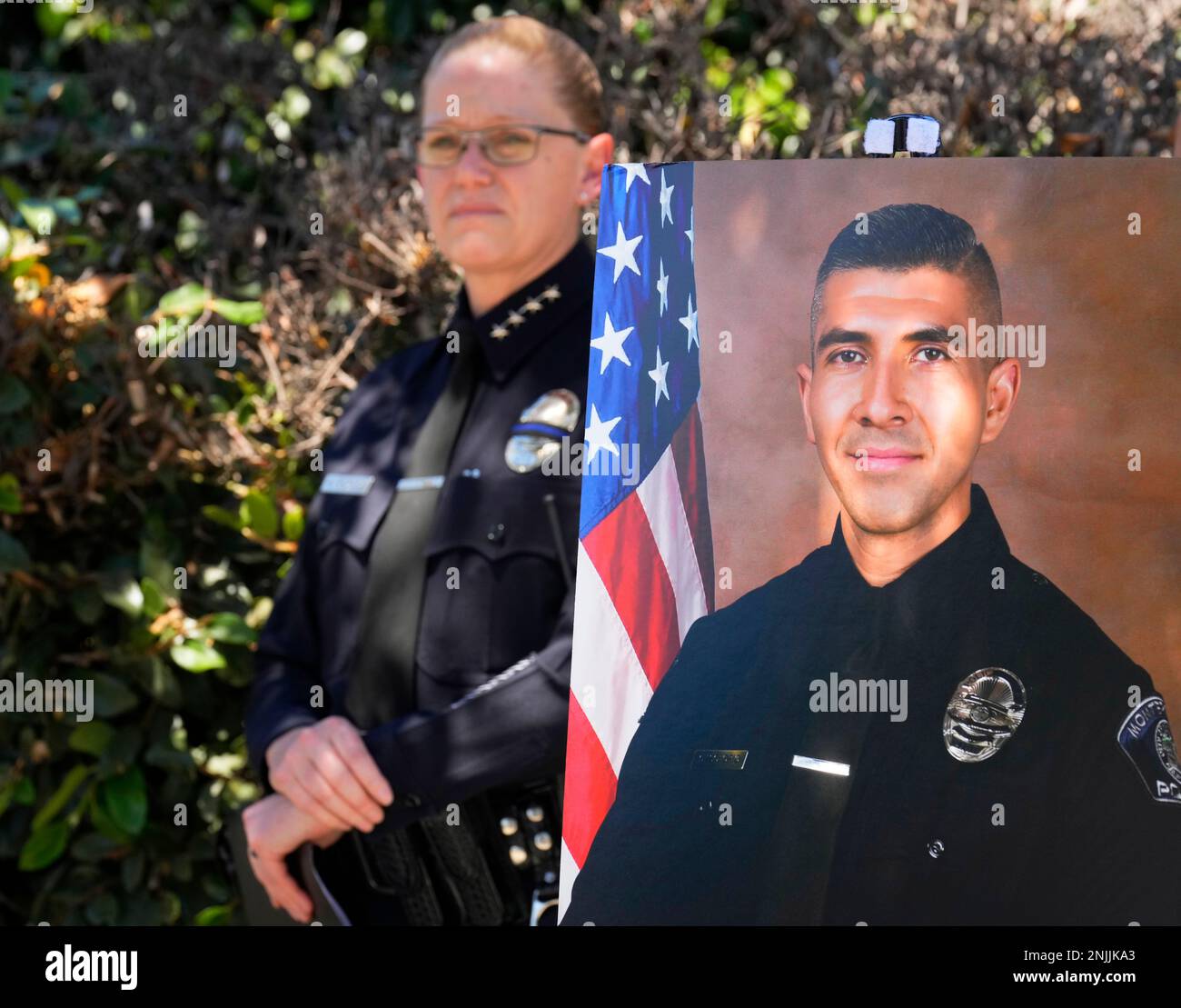 Monterey Park Chief of Police Kelly Gordon stands next to a picture ...