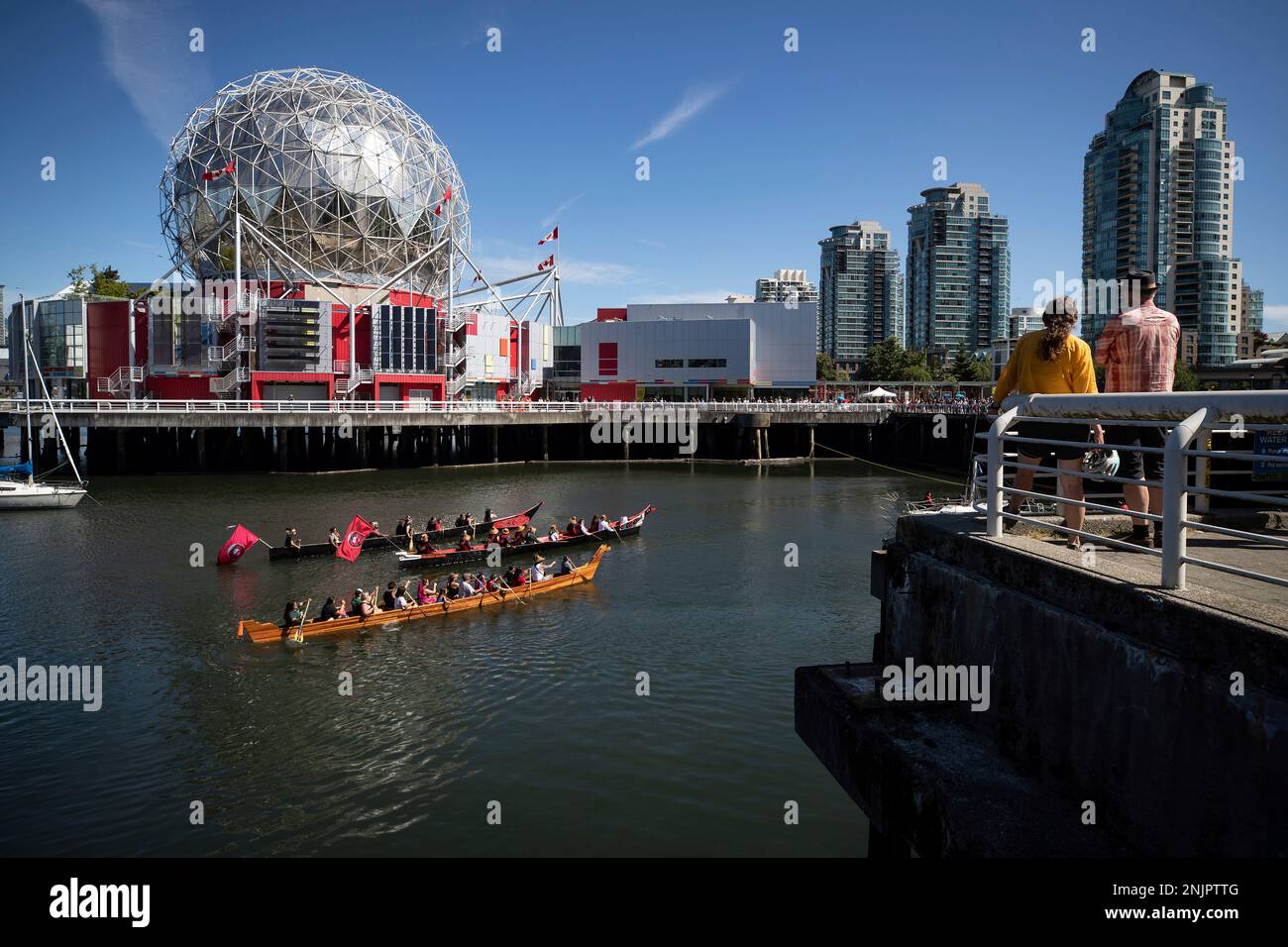People watch as First Nations members in traditional canoes gather on ...