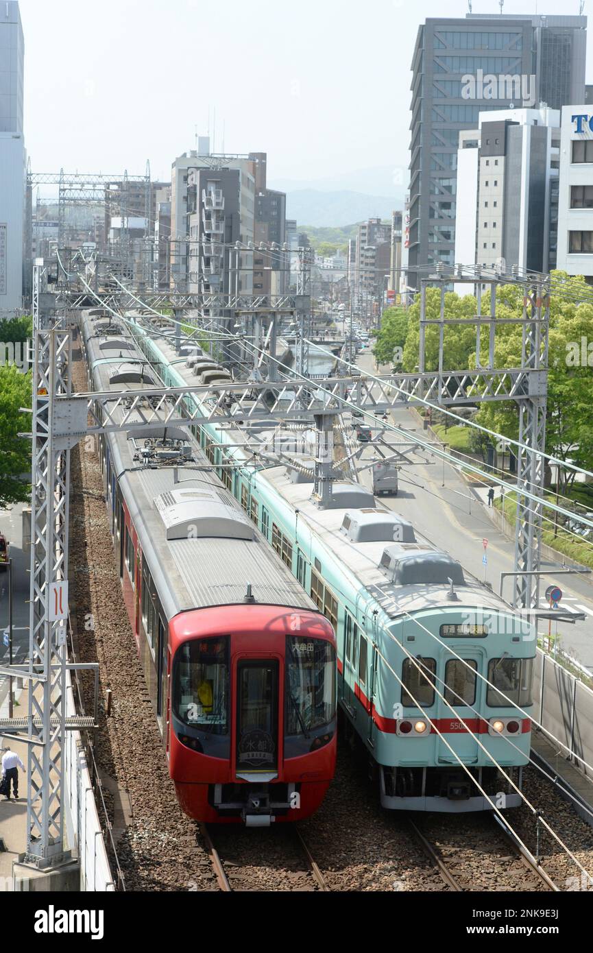 Trains of Nishi-Nippon Railroad Co., Ltd. run between buildings around ...