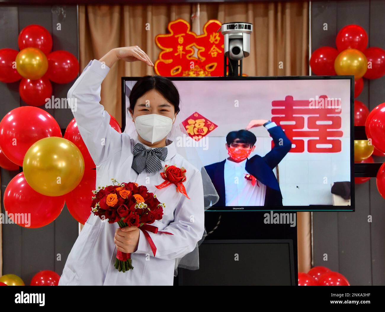 Feng Qianyao, a nurse at a local hospital, poses for photos with her groom Li Chunyu, both mask ...