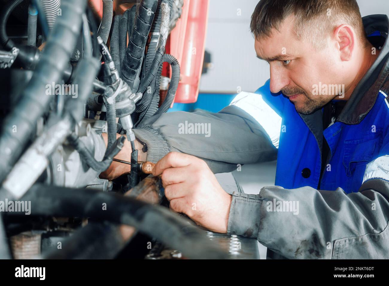 Automechaniker repariert großen Lkw oder Traktor in der Werkstatt ...
