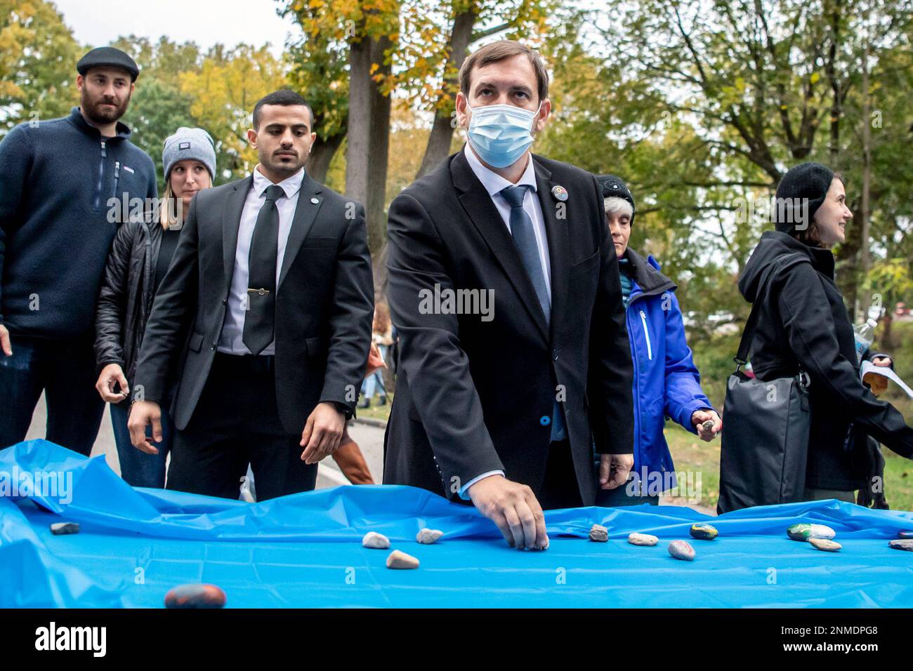Israel's Consul General, Asaf Zamir, center, places a stone of ...