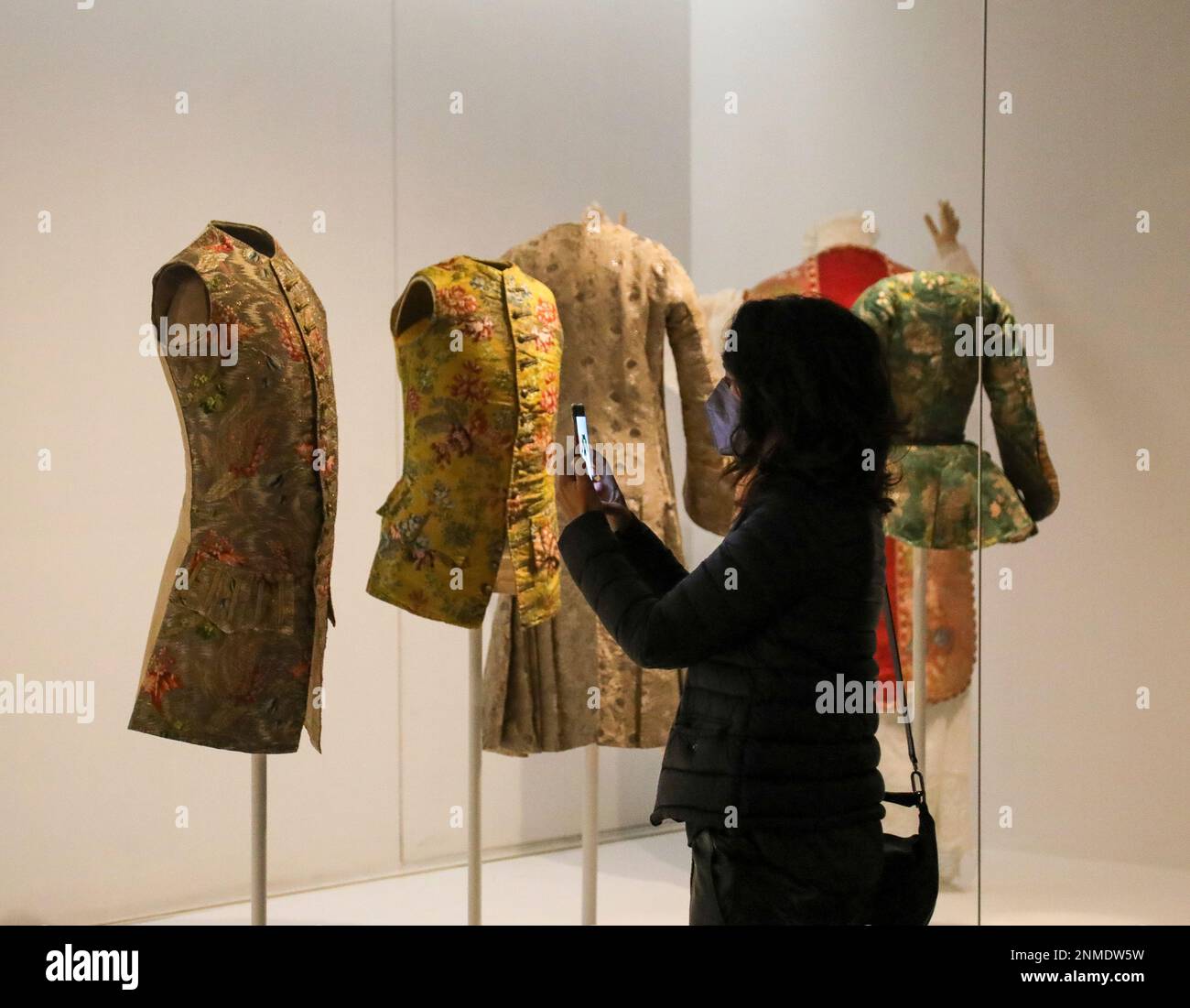 A person photographs one of the garments at the reopening of the Museo ...