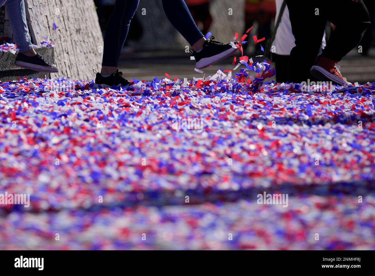 A woman kicks confetti after ceremonies marking the 37th anniversary of ...