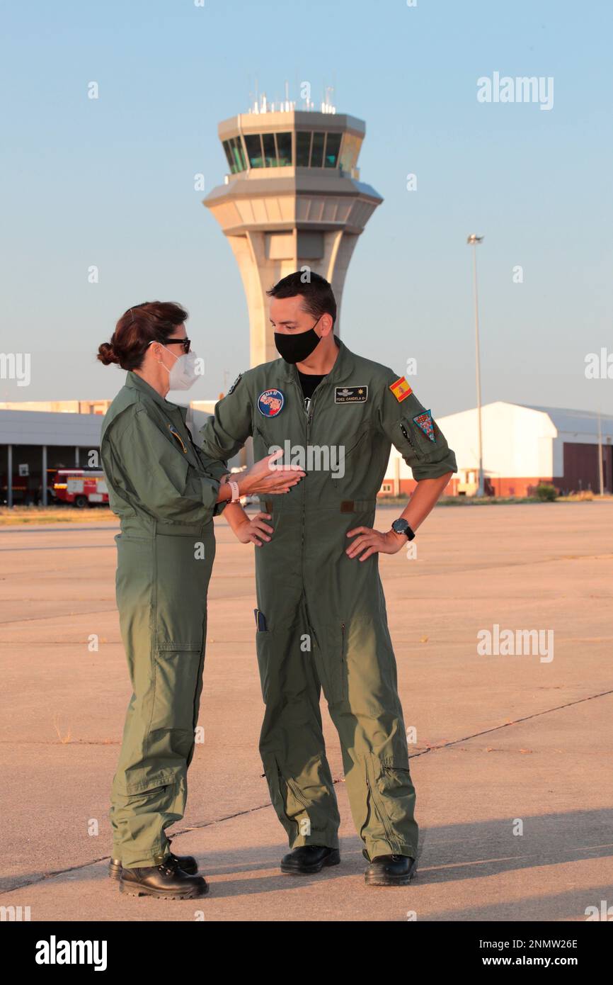 Two soldiers hold a conversation before boarding the plane that has ...