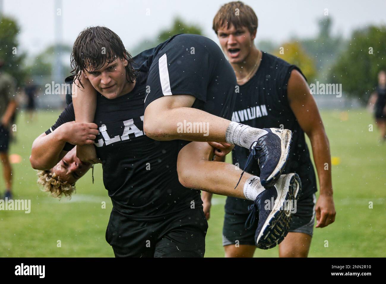 Heritage high school football player Miles Clark carries a teammate on ...