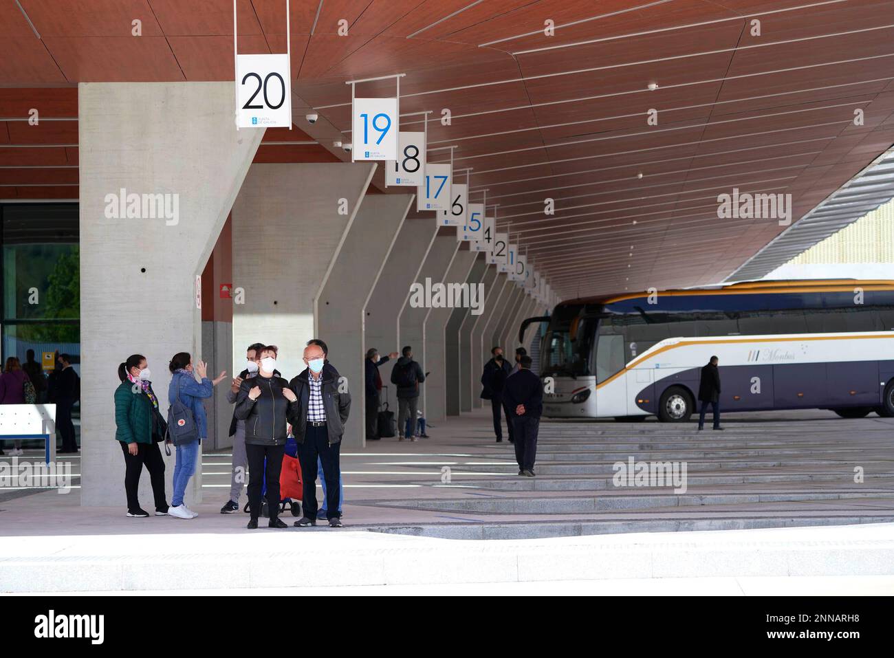 Several people wait for buses from one of the docks of the new bus ...