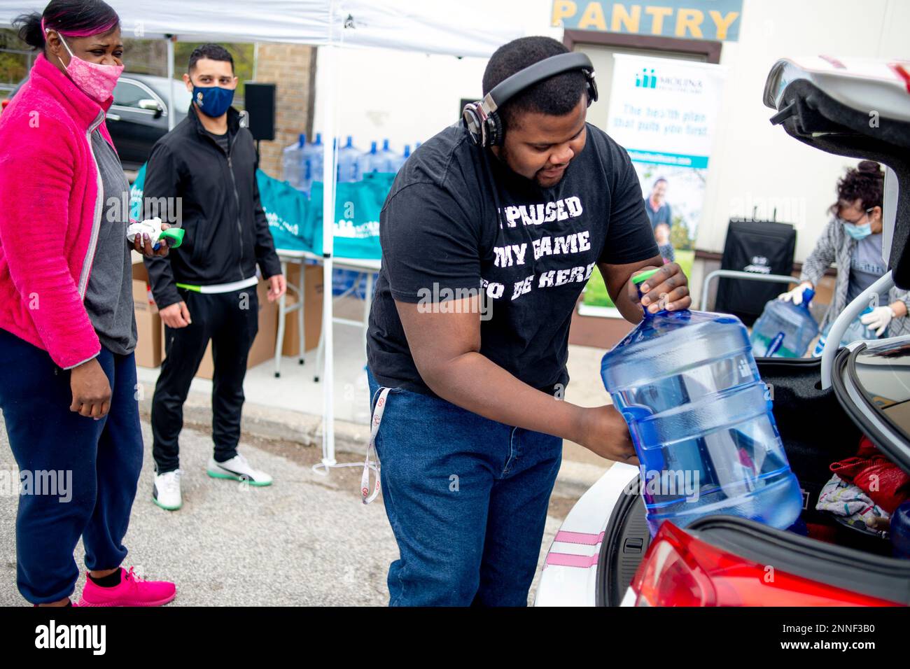 R-Mon Ford, 23 of Flint, puts freshly filled five-gallon jugs of water ...
