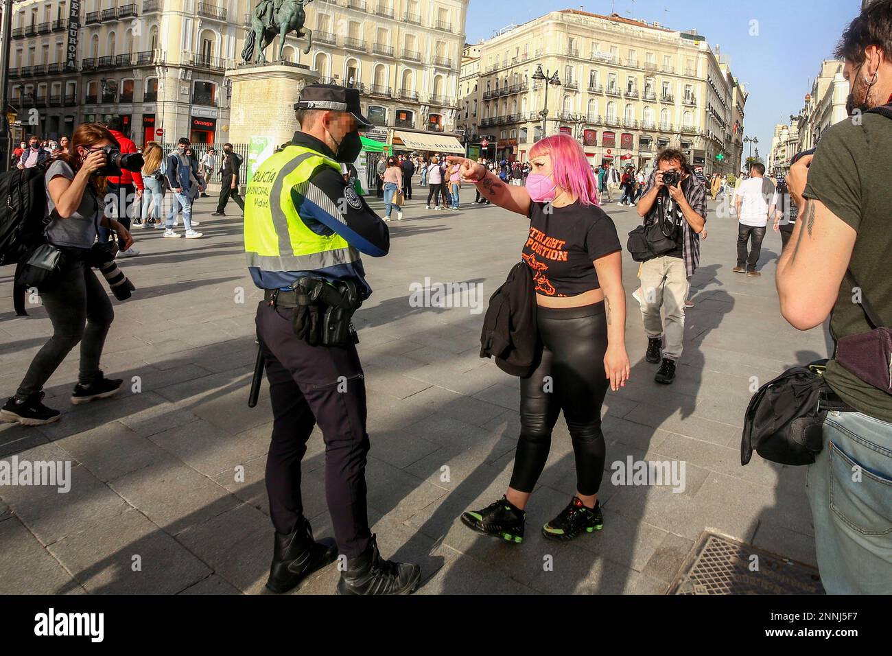 A neo-Nazi woman addresses a municipal police officer during a rally ...