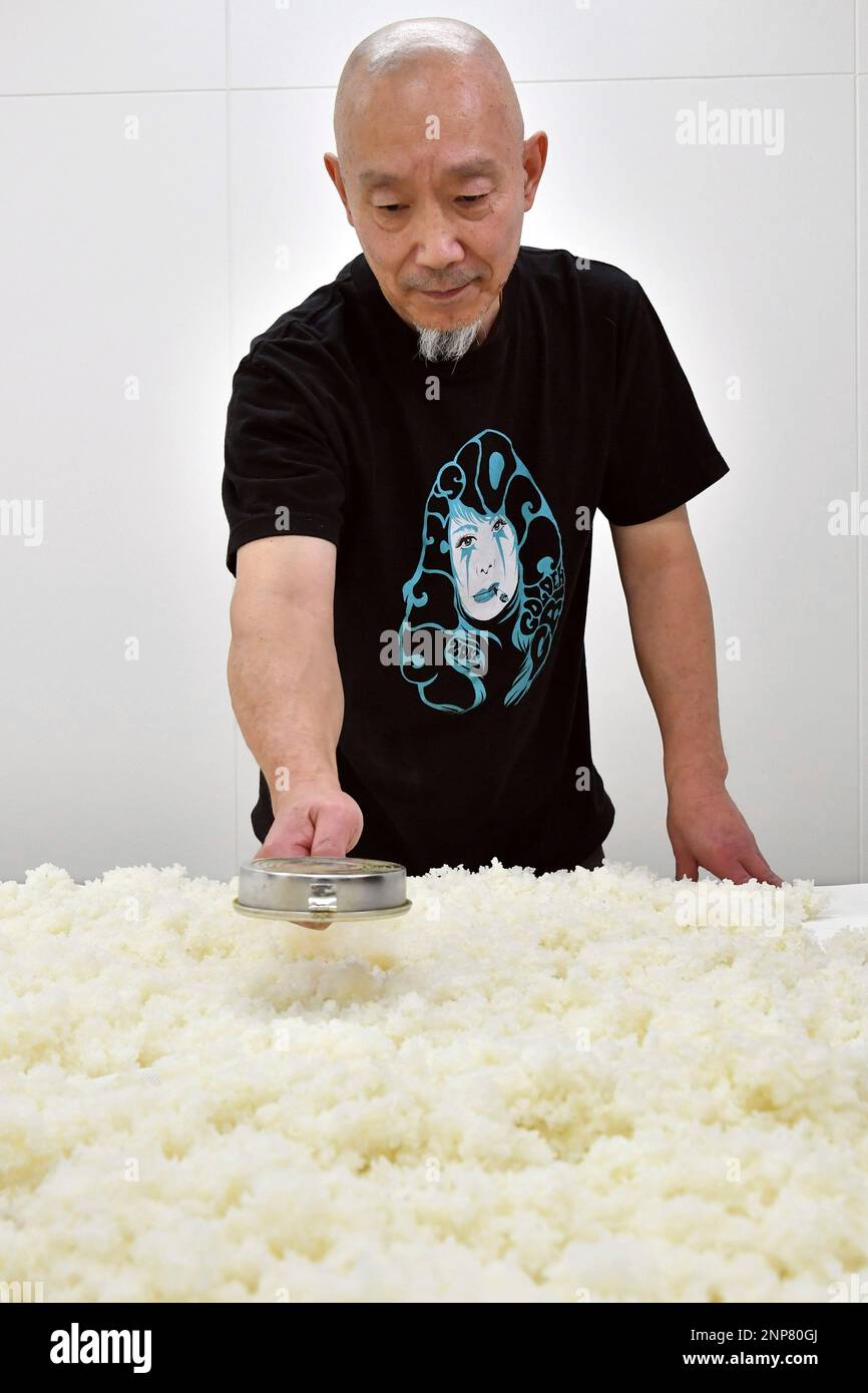 Craftsmen make sake (Japanese rice wine) by mixing steamed rice with ...