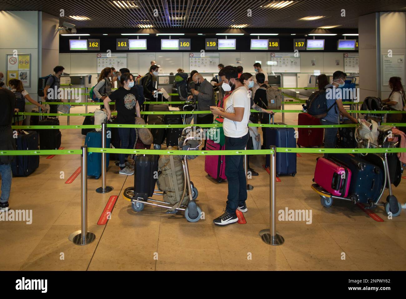 Passengers with suitcases queue up to check in at Terminal T1 of the ...