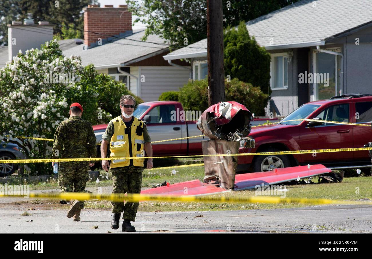 Members of the Canadian Forces walk past the tail section of a Snowbird ...