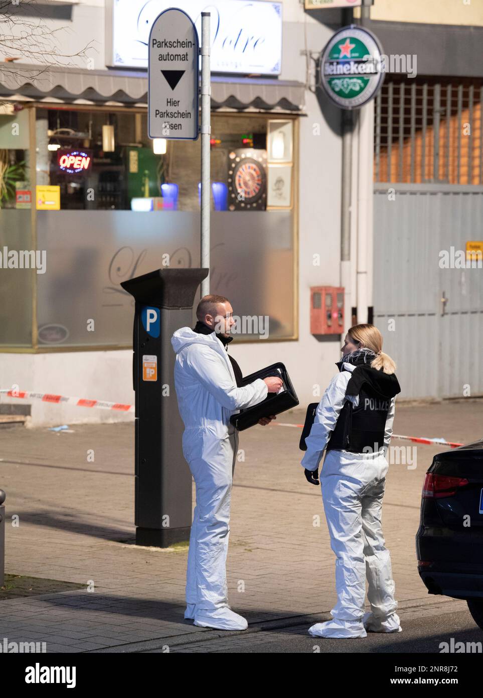 Police forensic officers stand near the scene of a shooting in Hanau ...