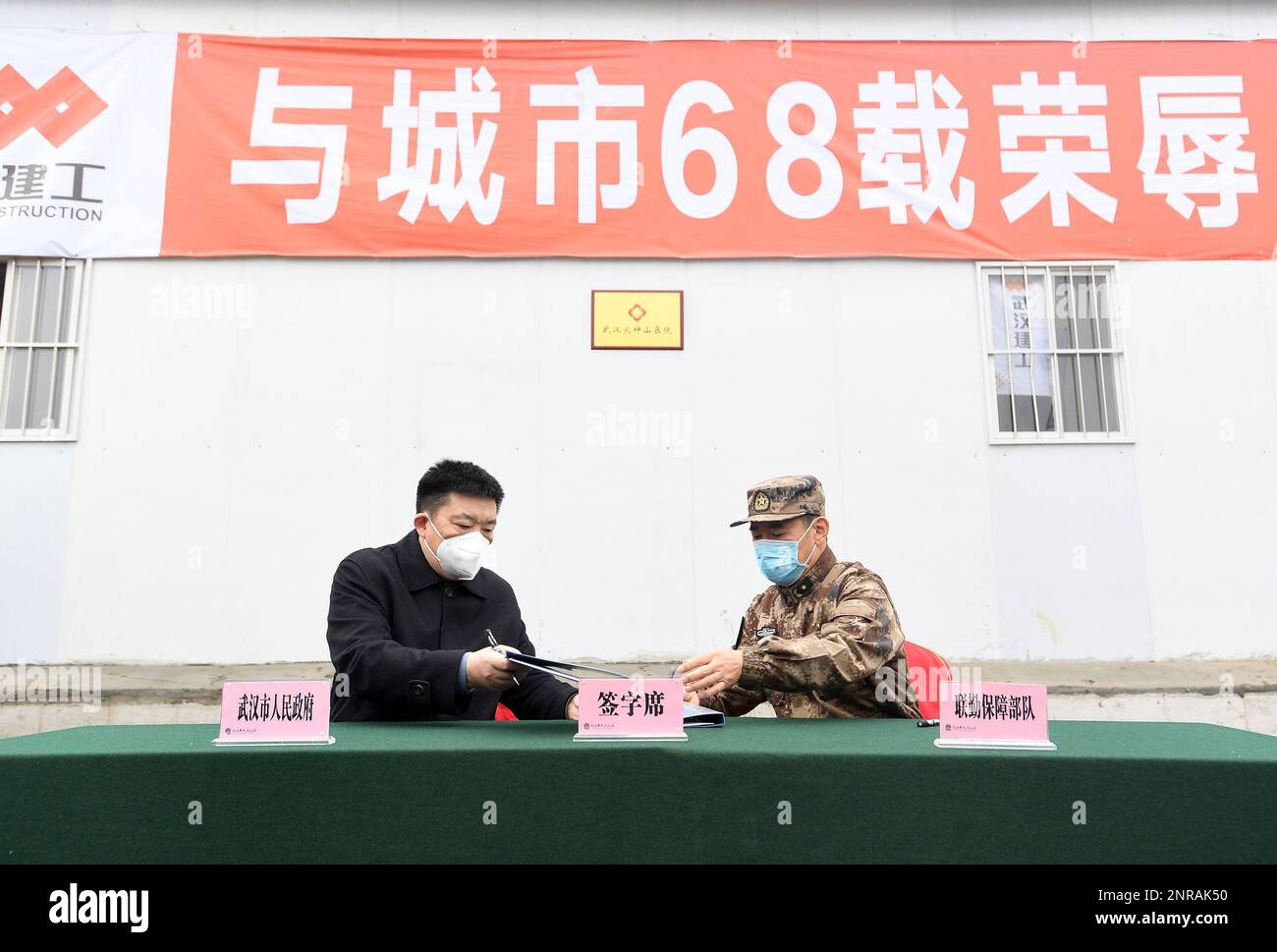Zhou Xianwang, left, mayor of Wuhan, exchanges documents with Bai Zhongbin, right, deputy ...