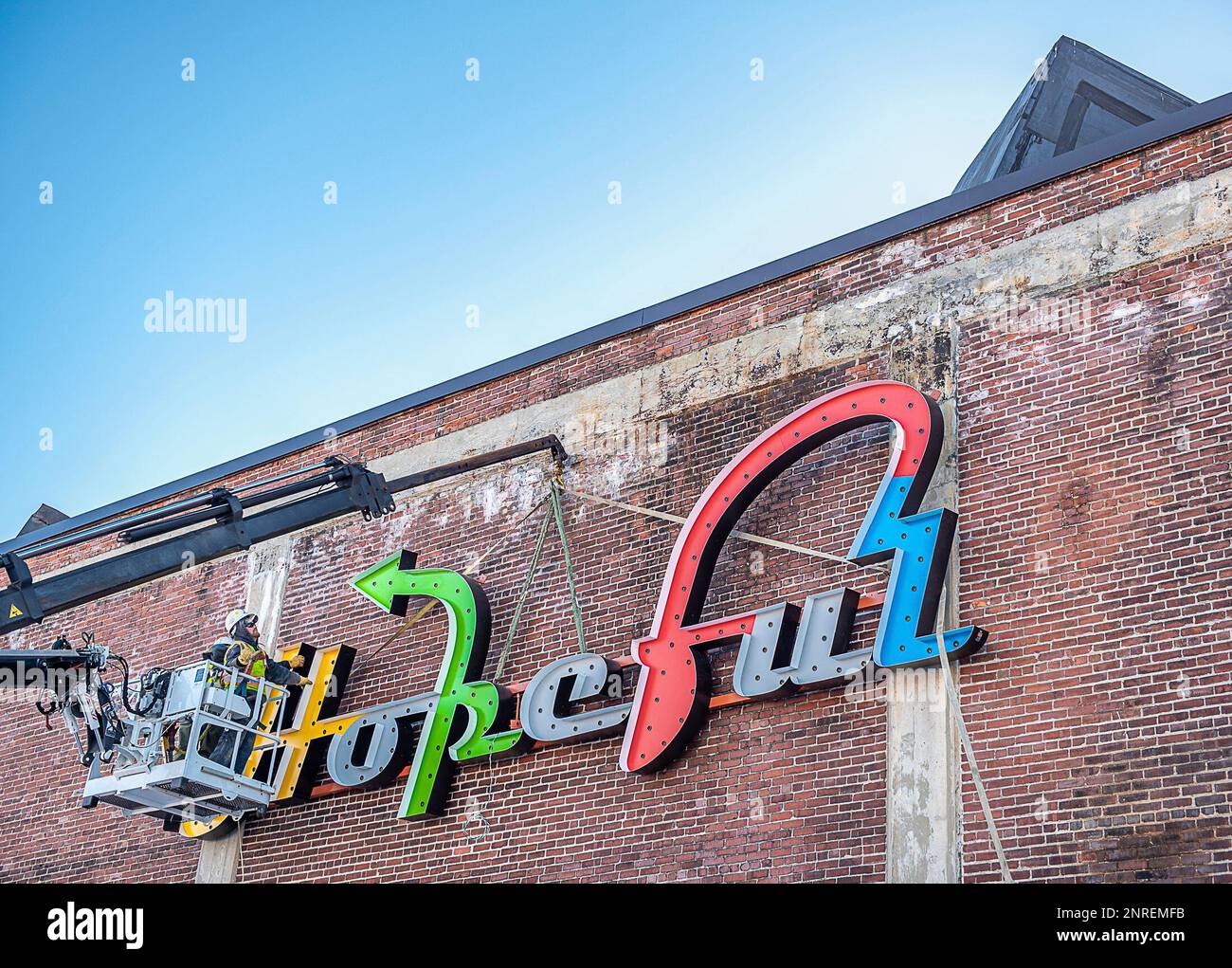 Charlie Hewitt's "Hopeful" sign is installed on the side of Bates Mill ...