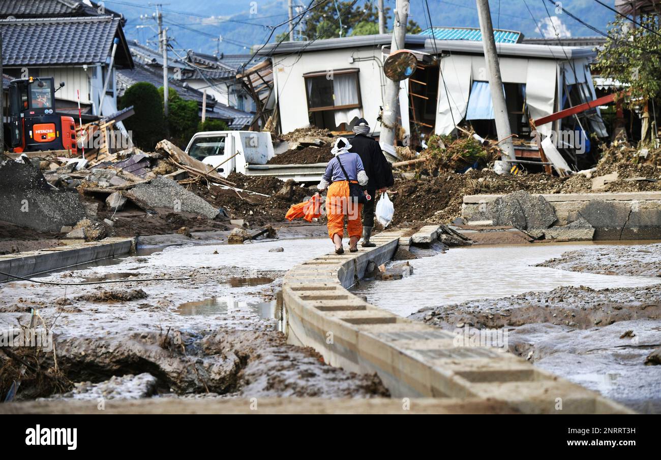 Suffers walk through a disaster area which was flooded in Nagano City ...