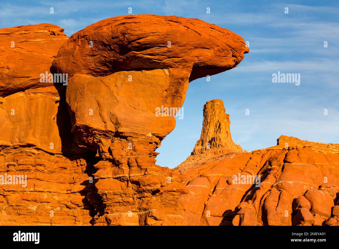 Ein Wingate Sandstone butte, eingerahmt von einer gestreiften Cutler ...