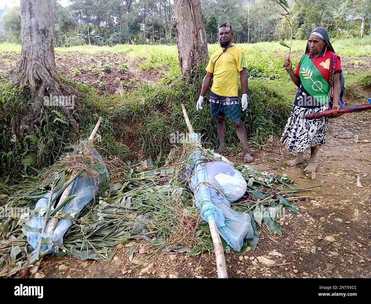 In this Monday, July 8, 2019, photo, locals stand by the bodies of ...