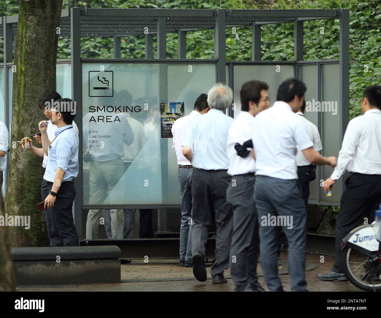 Office workers gather at a smoking area at noon in Shinjuku Ward, Tokyo ...