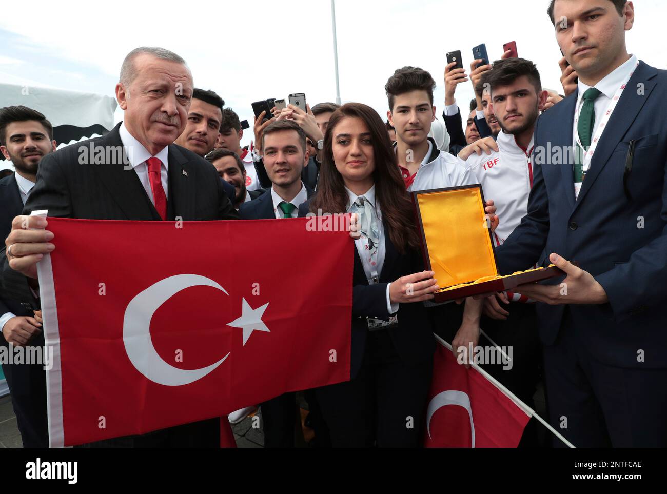 Turkey's President Recep Tayyip Erdogan holds up a national flag he ...