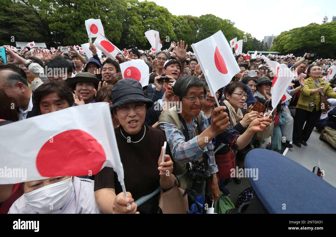 People celebrating Emperor's enthronement wave Japanese national flag ...