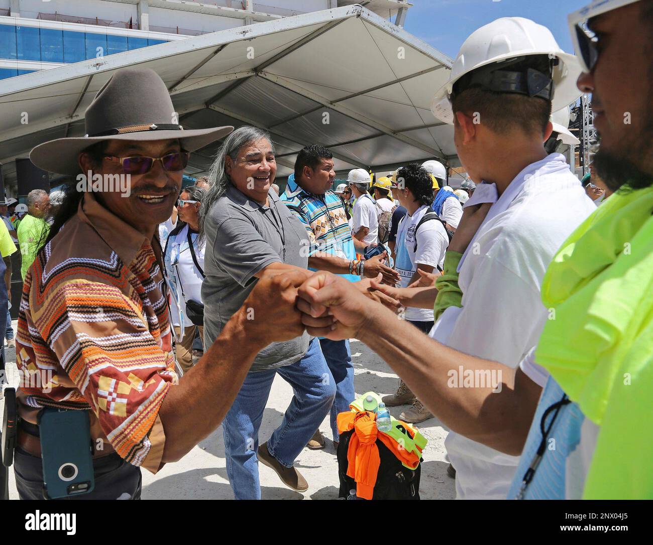 Tribal members thank construction workers with a handshakes and fist ...