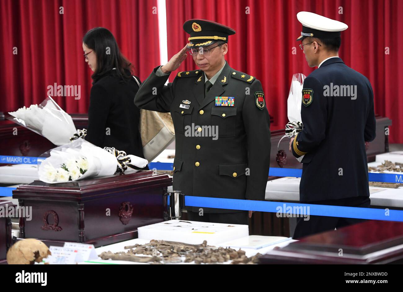 A Chinese military officer salutes near the remains of Chinese soldiers ...