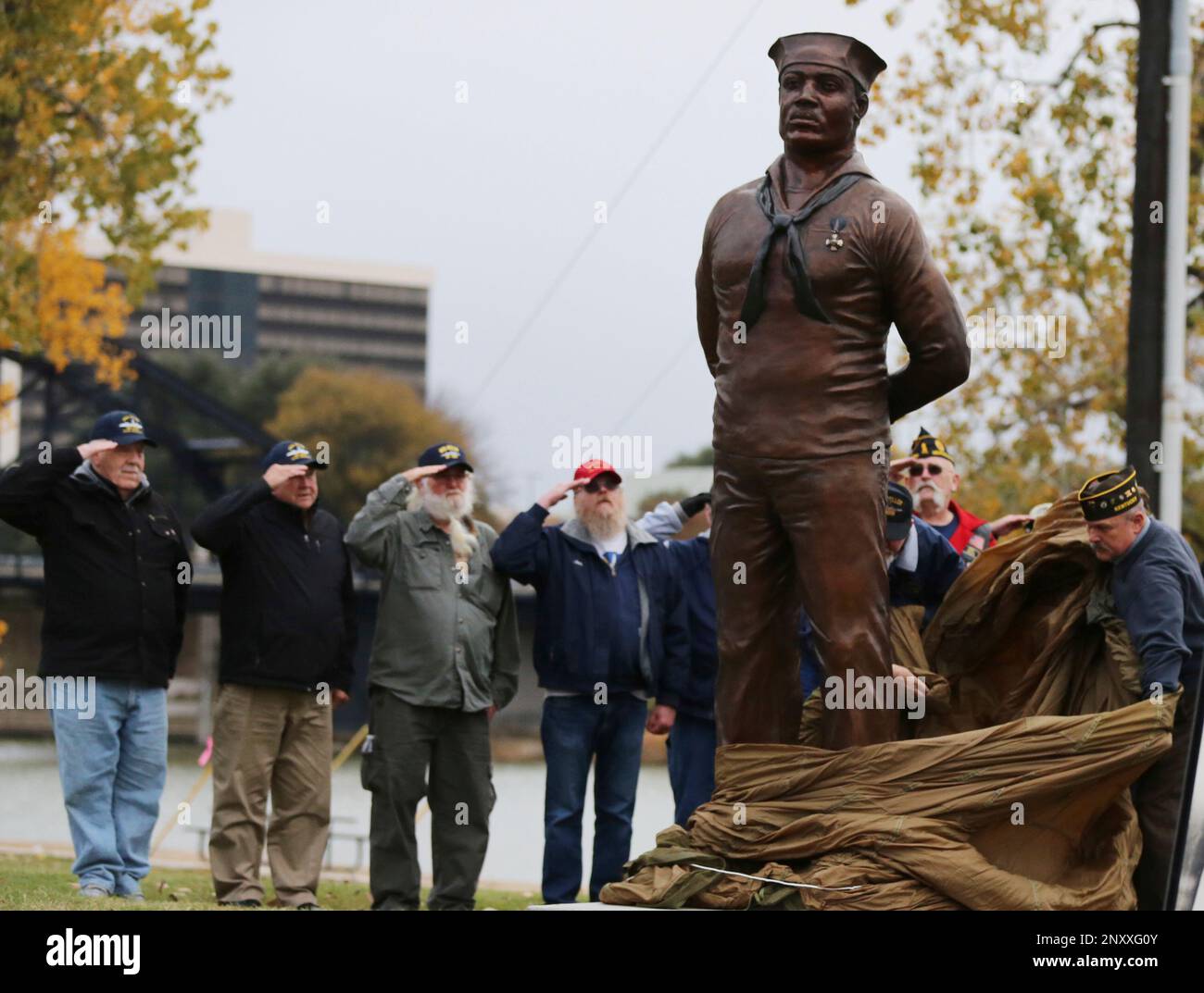 Former sailors on the USS Miller, salute a 9-foot-tall bronze statue ...